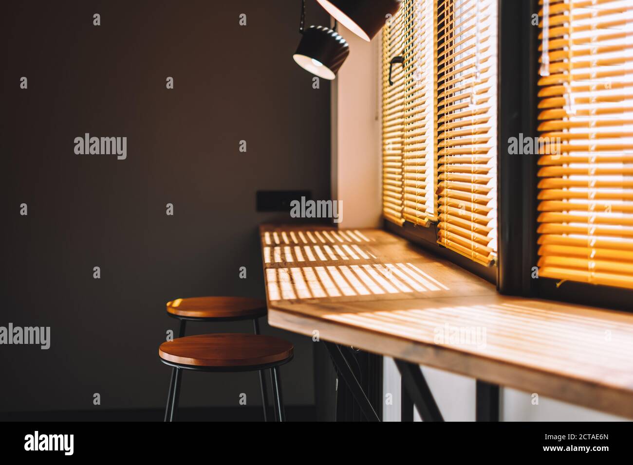 Modern wooden table on the kitchen near big window with curtain ...