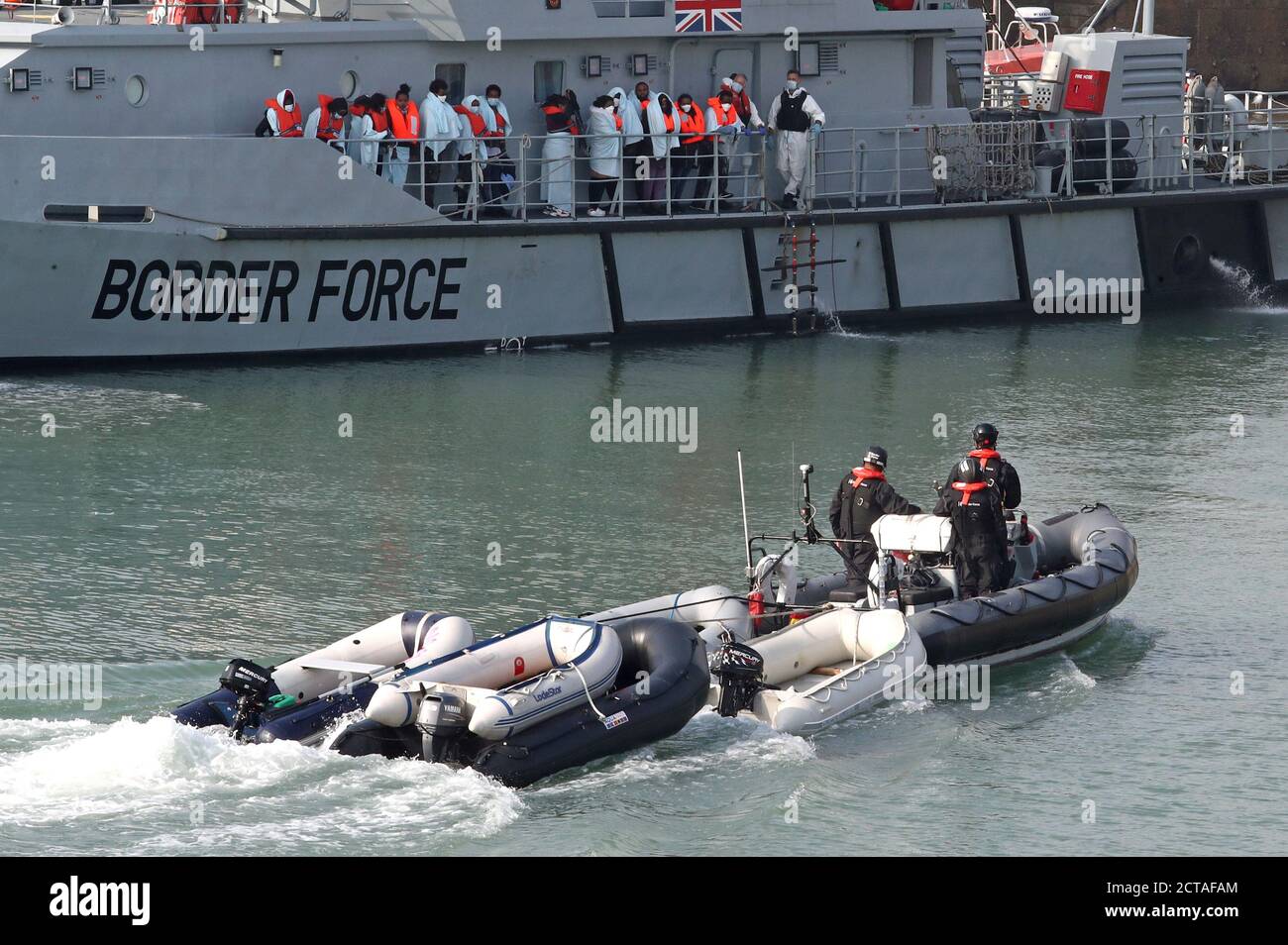 Three Border Force officers aboard a Border Force rib, towing a ...