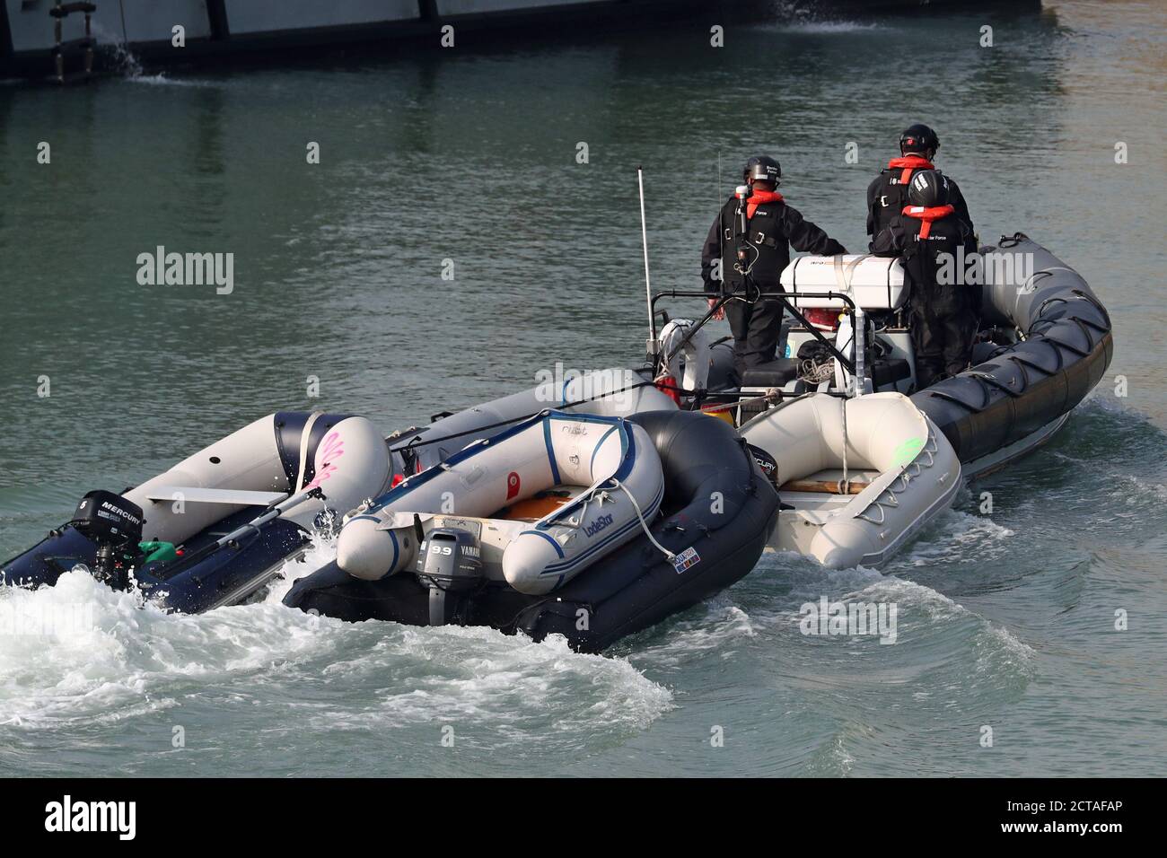 Three border force officers aboard a border force rib hi-res stock ...