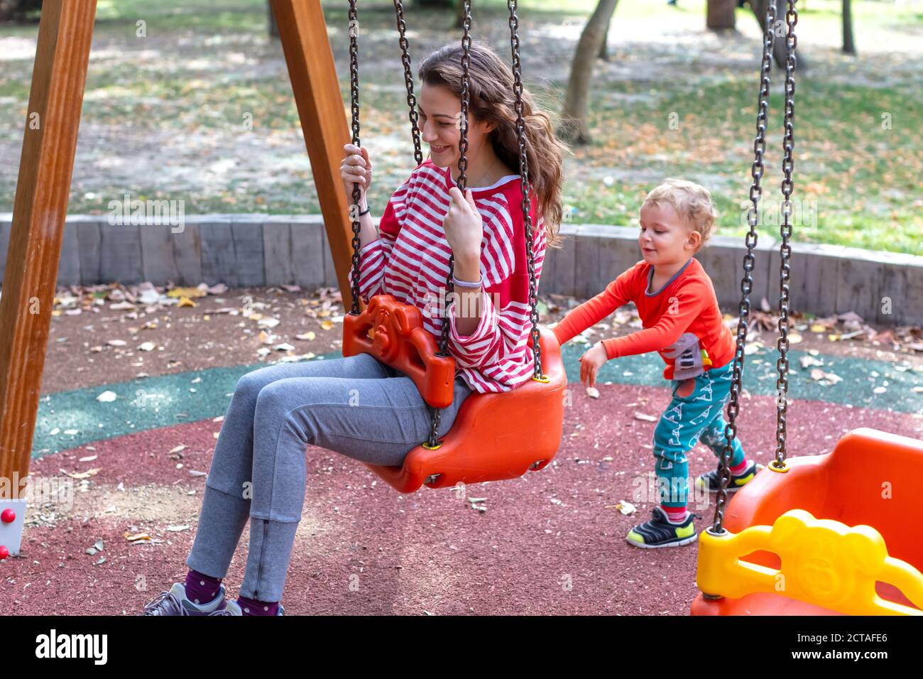 Son Swinging his Mother on a Swing Stock Photo - Alamy