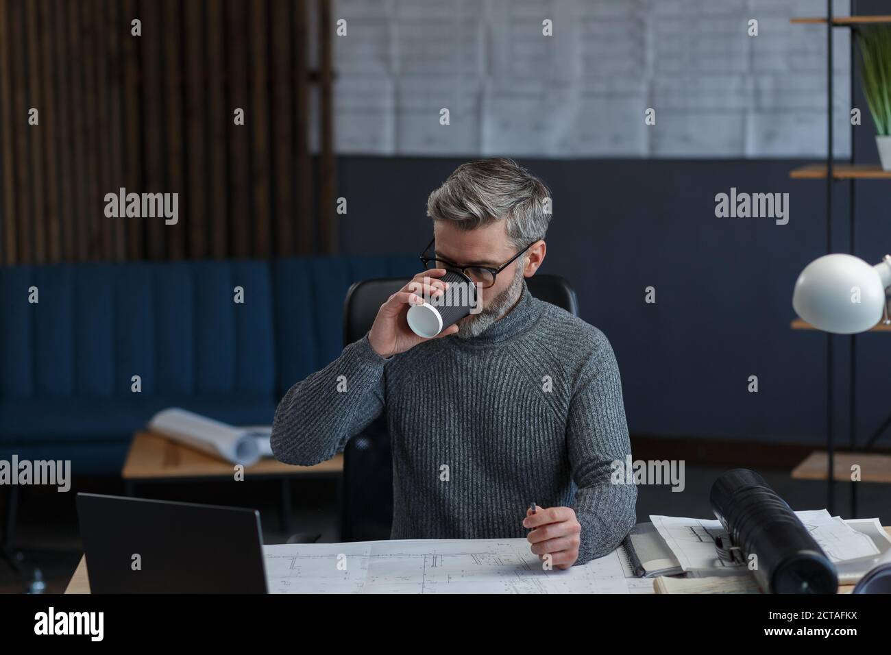 Designer working in office with laptop. Architect thinks over ...