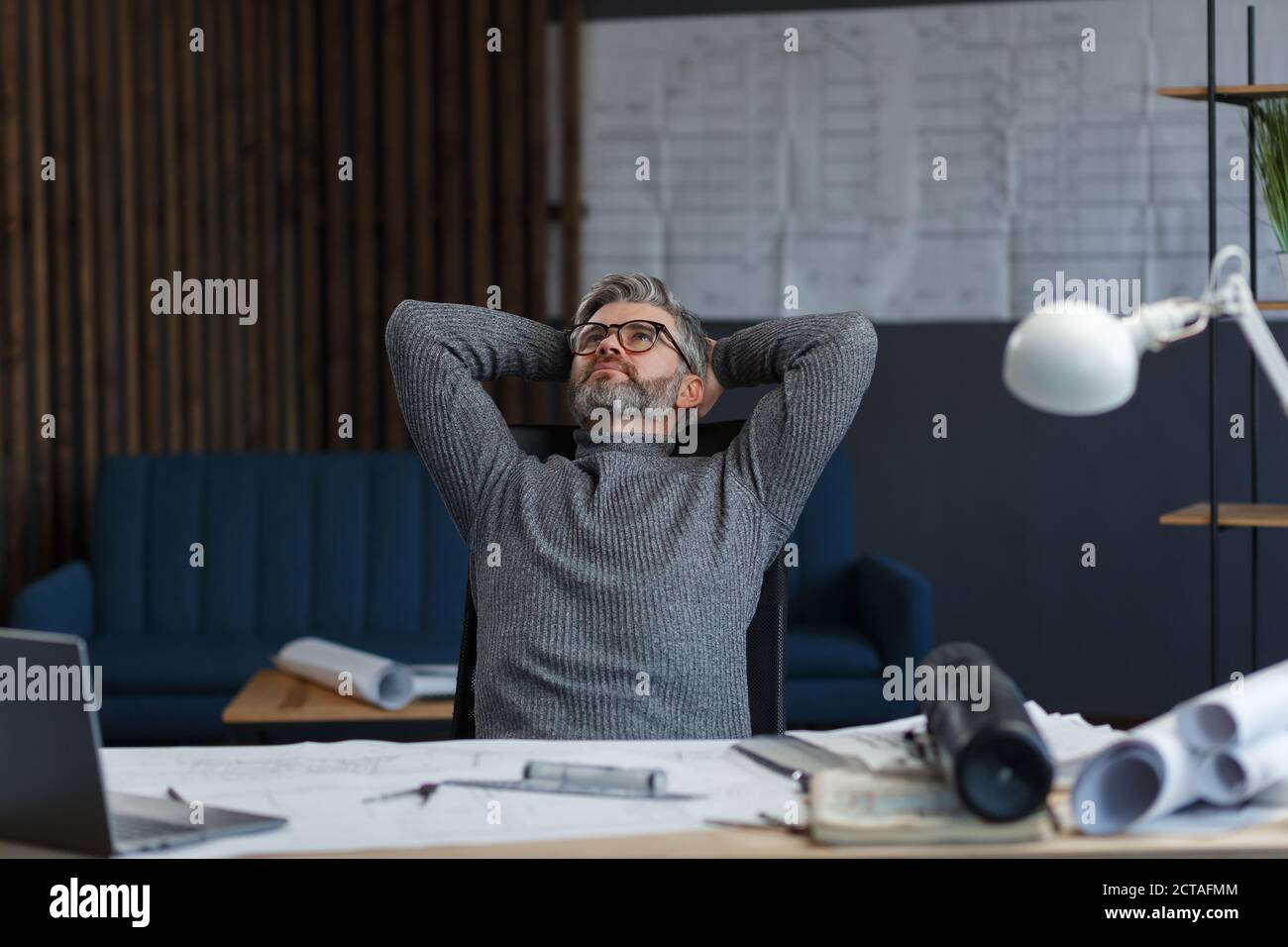 Designer takes a break from work in office.Architect thinks over ...