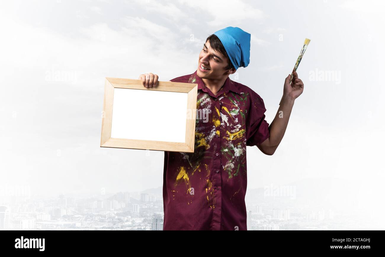 Young handsome painter artist holding paintbrush Stock Photo - Alamy