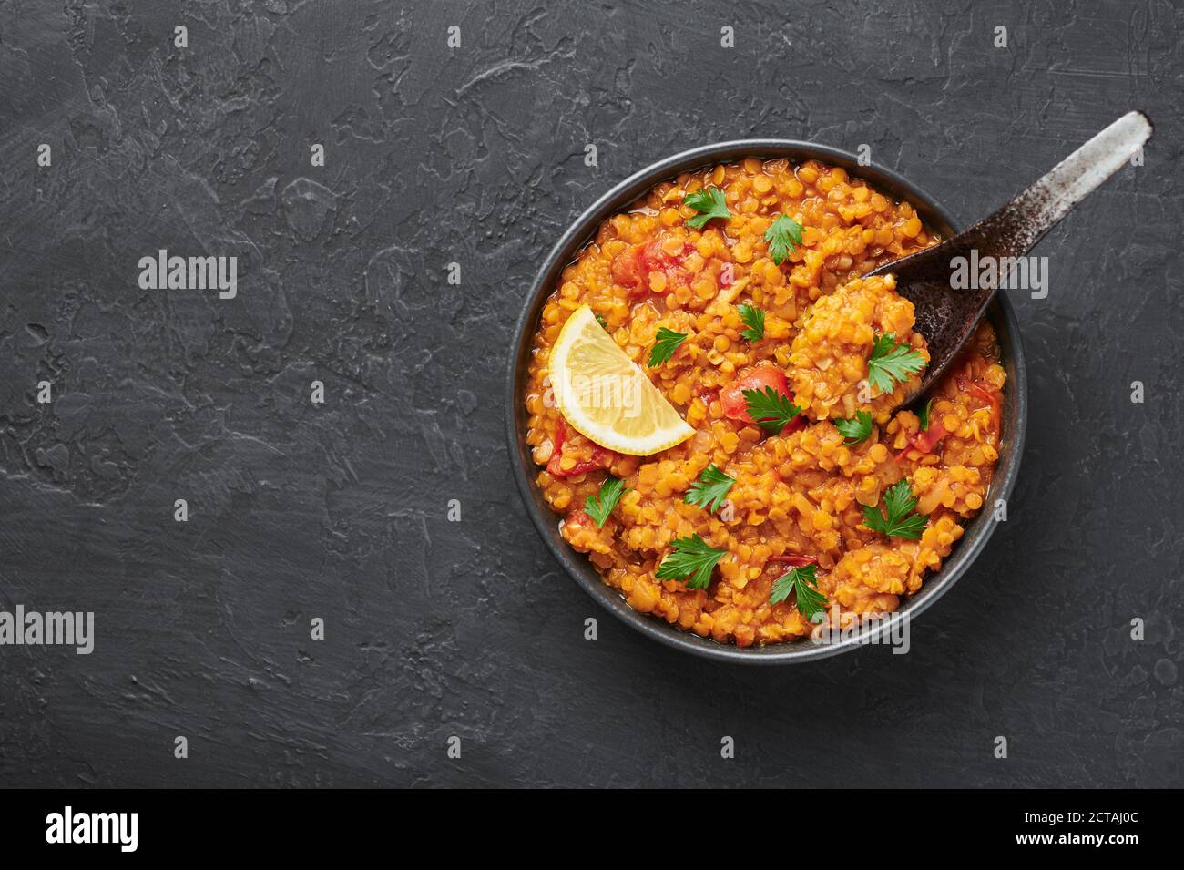 Red lentils dal in black bowl on dark slate table top. Lentils tomato ...