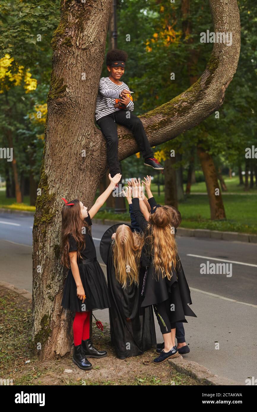 Vertical shot of group of children dressed in halloween costumes ...