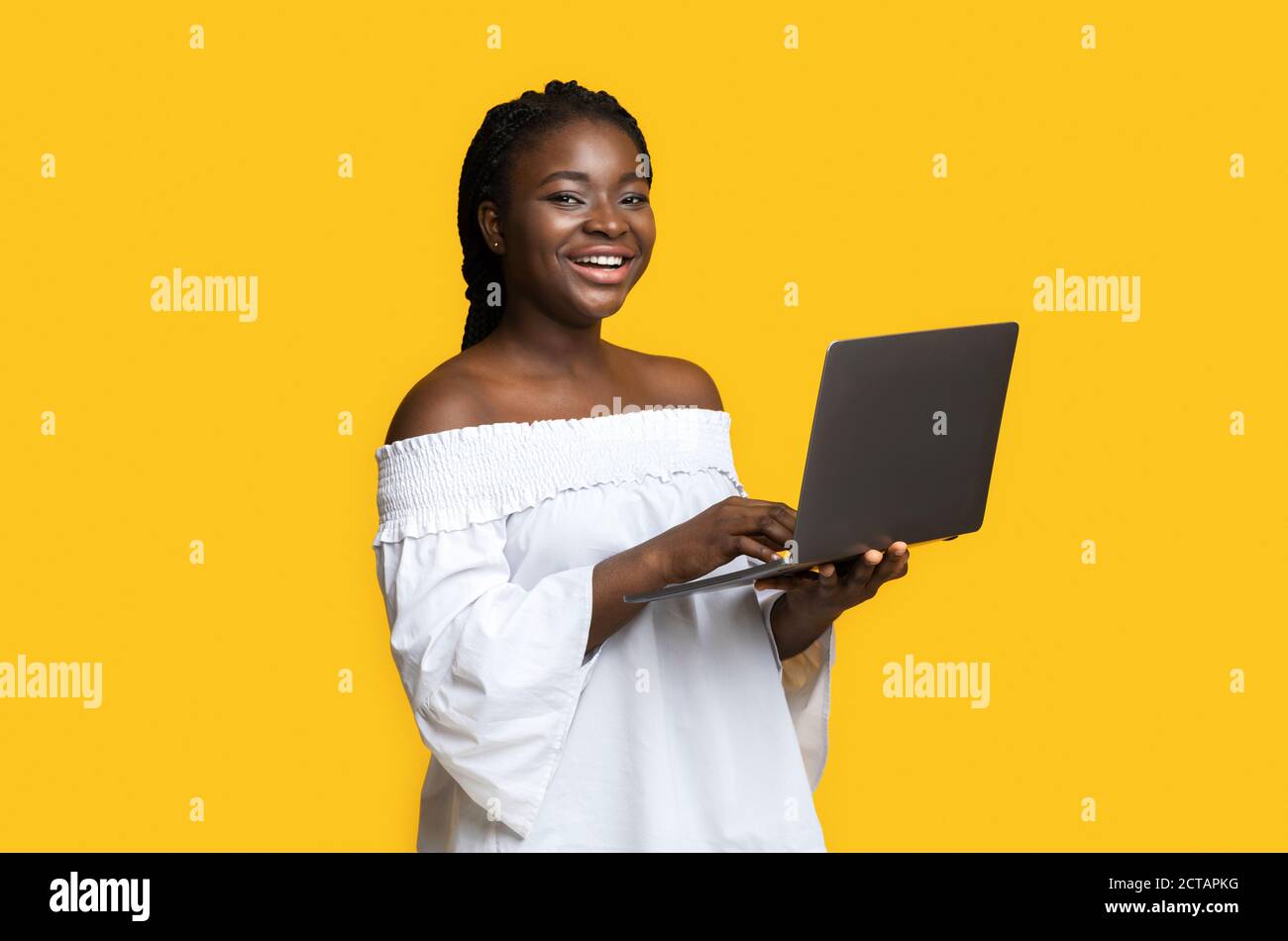 Cheerful Black Woman Posing With Laptop In Hands Over Yellow Studio ...