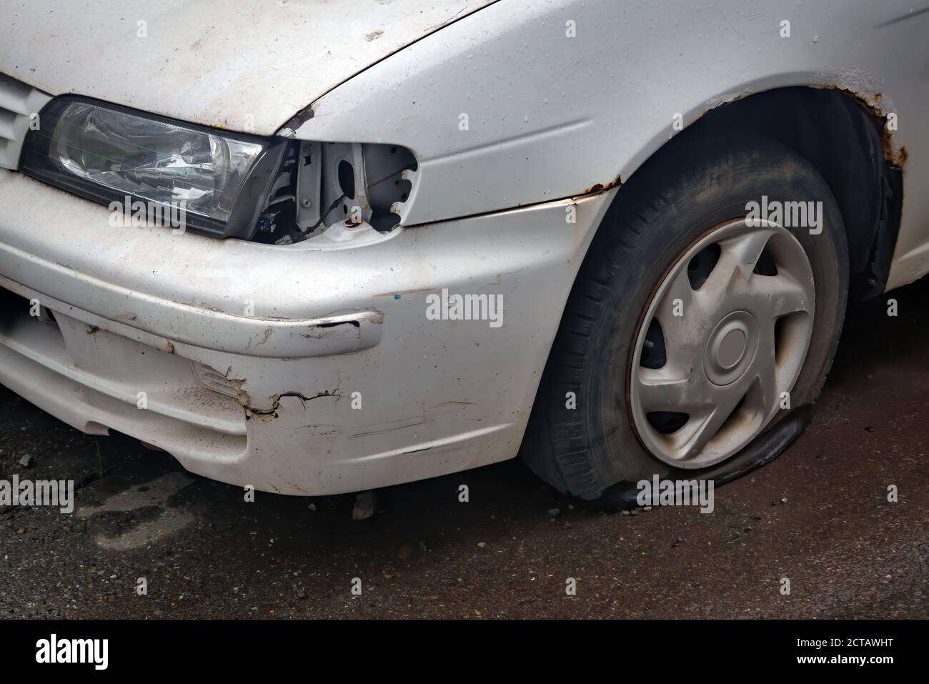 Fragment of old rusty white passenger car sedan with flat tires Stock ...