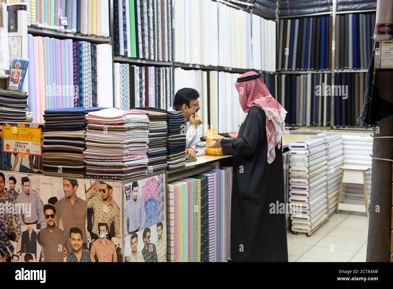 Arabic man wearing his dishdasha choosing his fabric in the textile ...