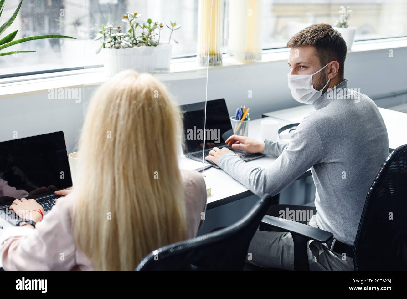 Social distance and working in modern office. Colleagues are guy and ...