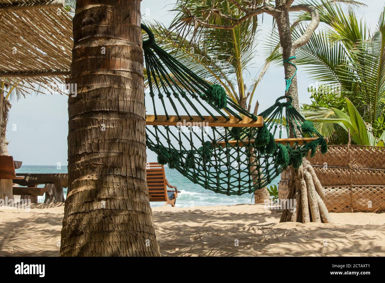 Romantic cozy hammock in the shadow of the palm on the tropical beach ...