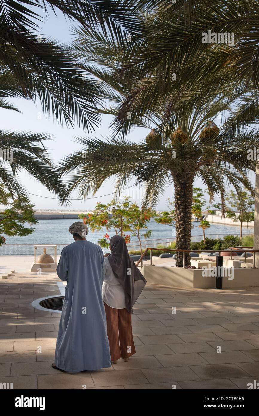 Couple walking by the park close to the marina. Al Mouj, The Wave ...