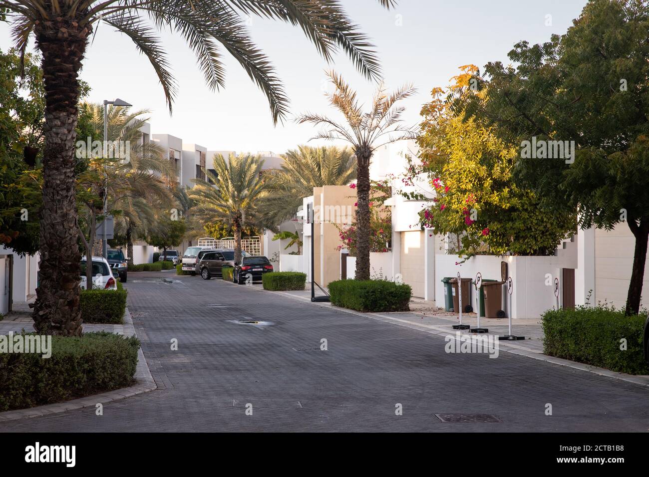 Street with villas and parked cars in compound. Al Mouj, The Wave ...