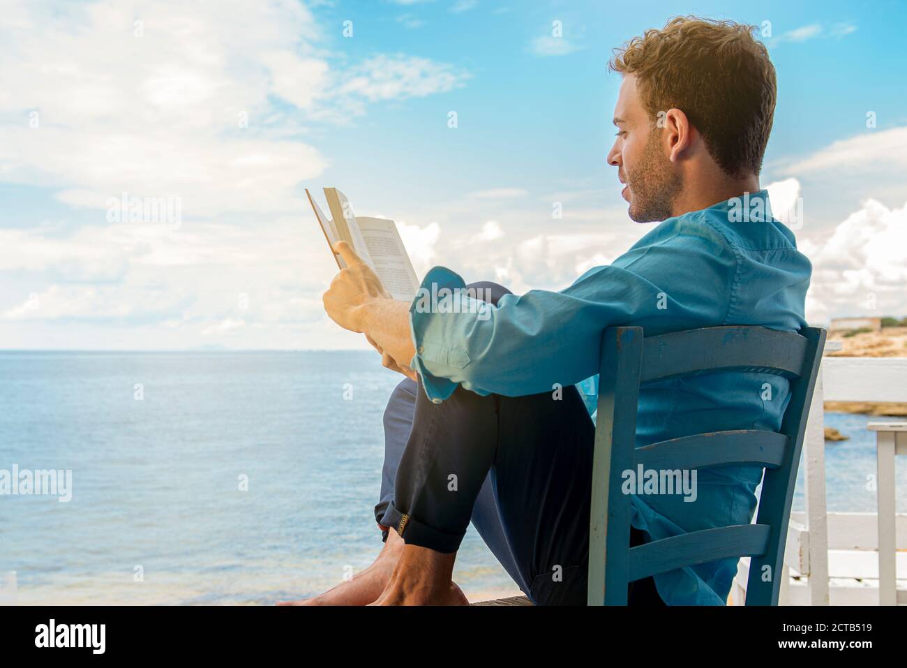 Young man reading beach chair alone hi-res stock photography and images ...