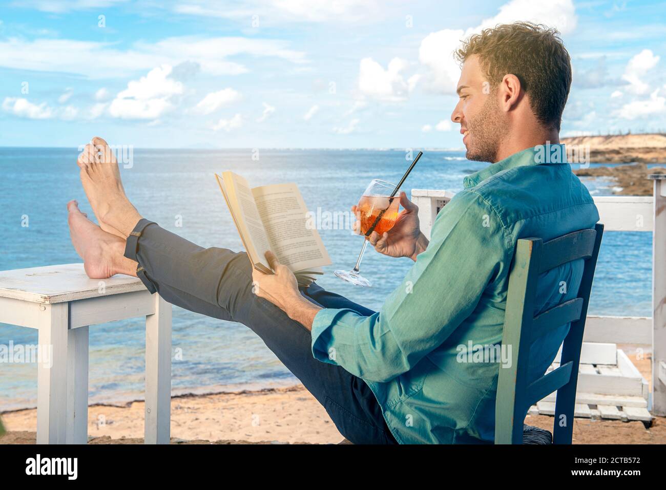 Relaxed man reading book at sea enjoying summer vacations on beautiful ...