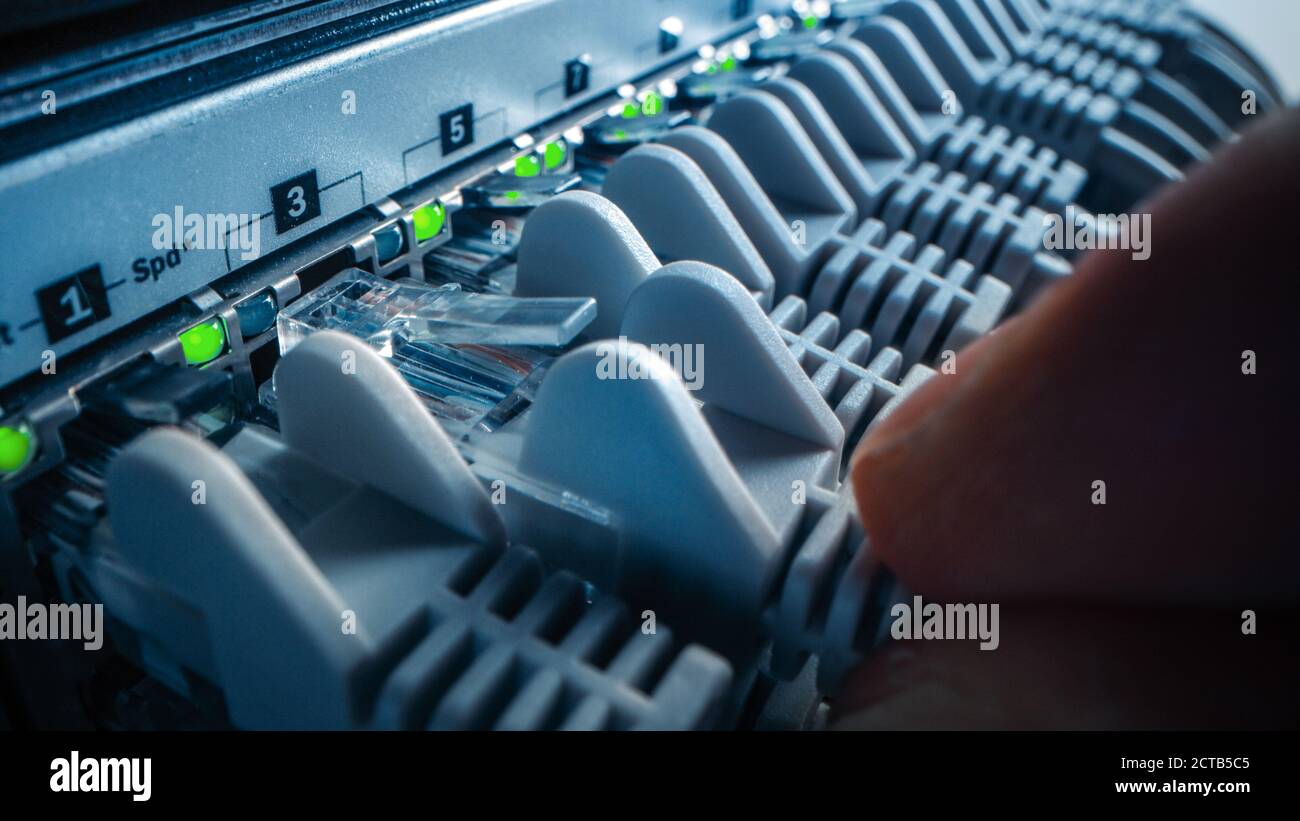 Macro Shot: Person Plugs in RJ45 Internet Connector into LAN Router ...