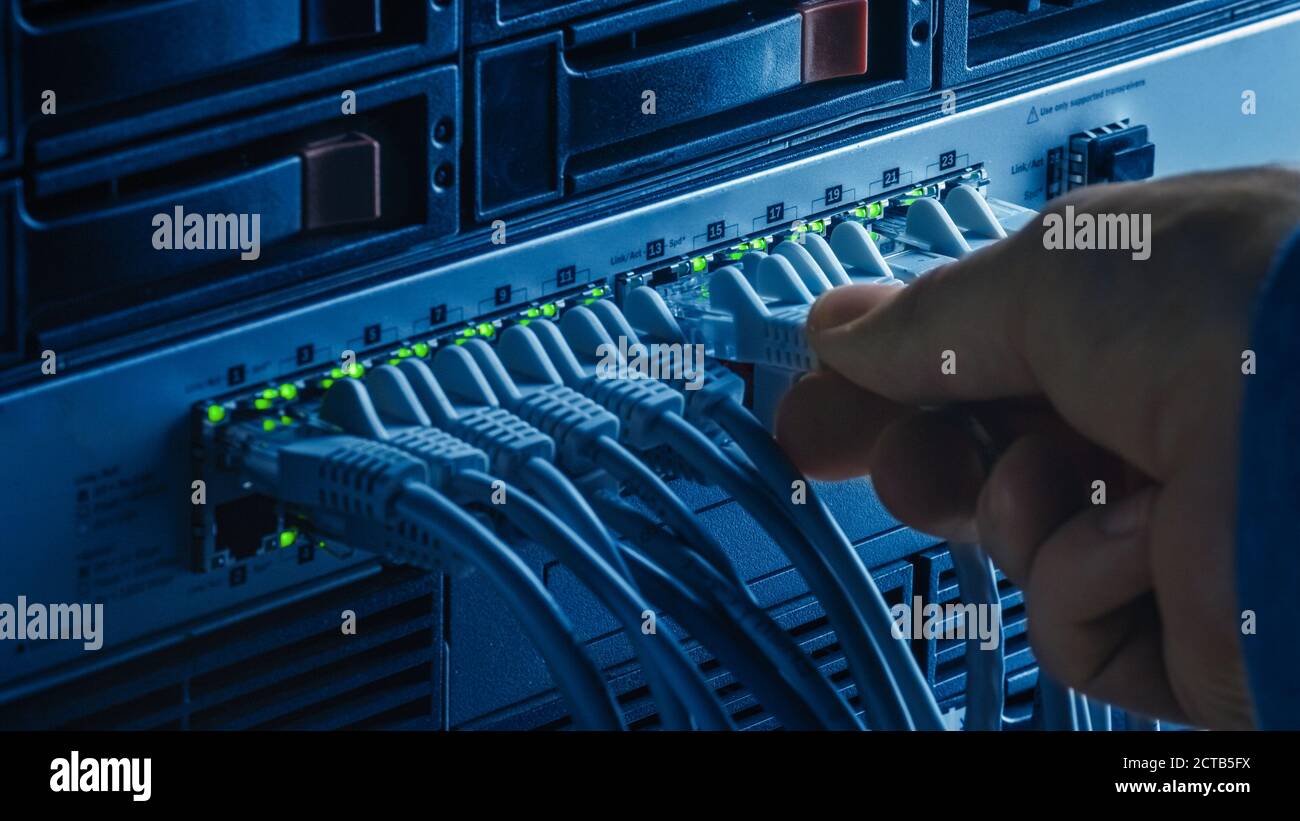 Macro Shot: Person Plugs in RJ45 Internet Connector into LAN Router ...