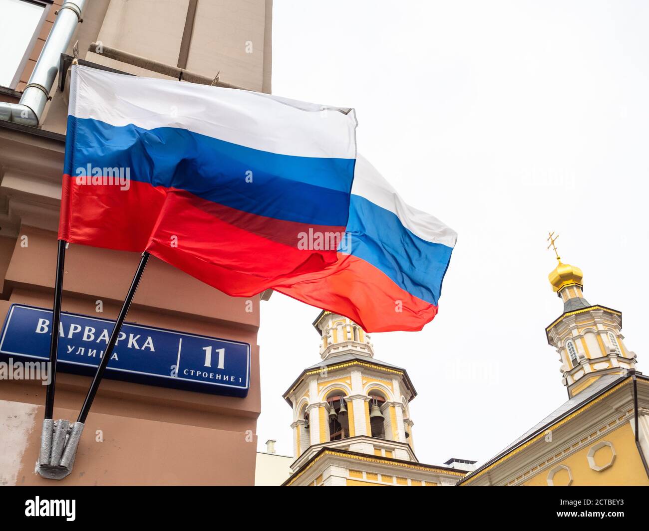 Russian state flag on wall of city house fluttering in wind near Church ...