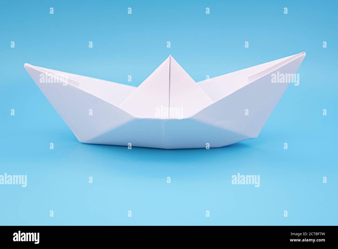 Paper ship origami on blue background surface as water Stock Photo - Alamy