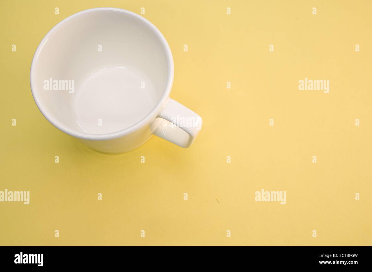High angle shot of an empty cup on a yellow surface Stock Photo - Alamy