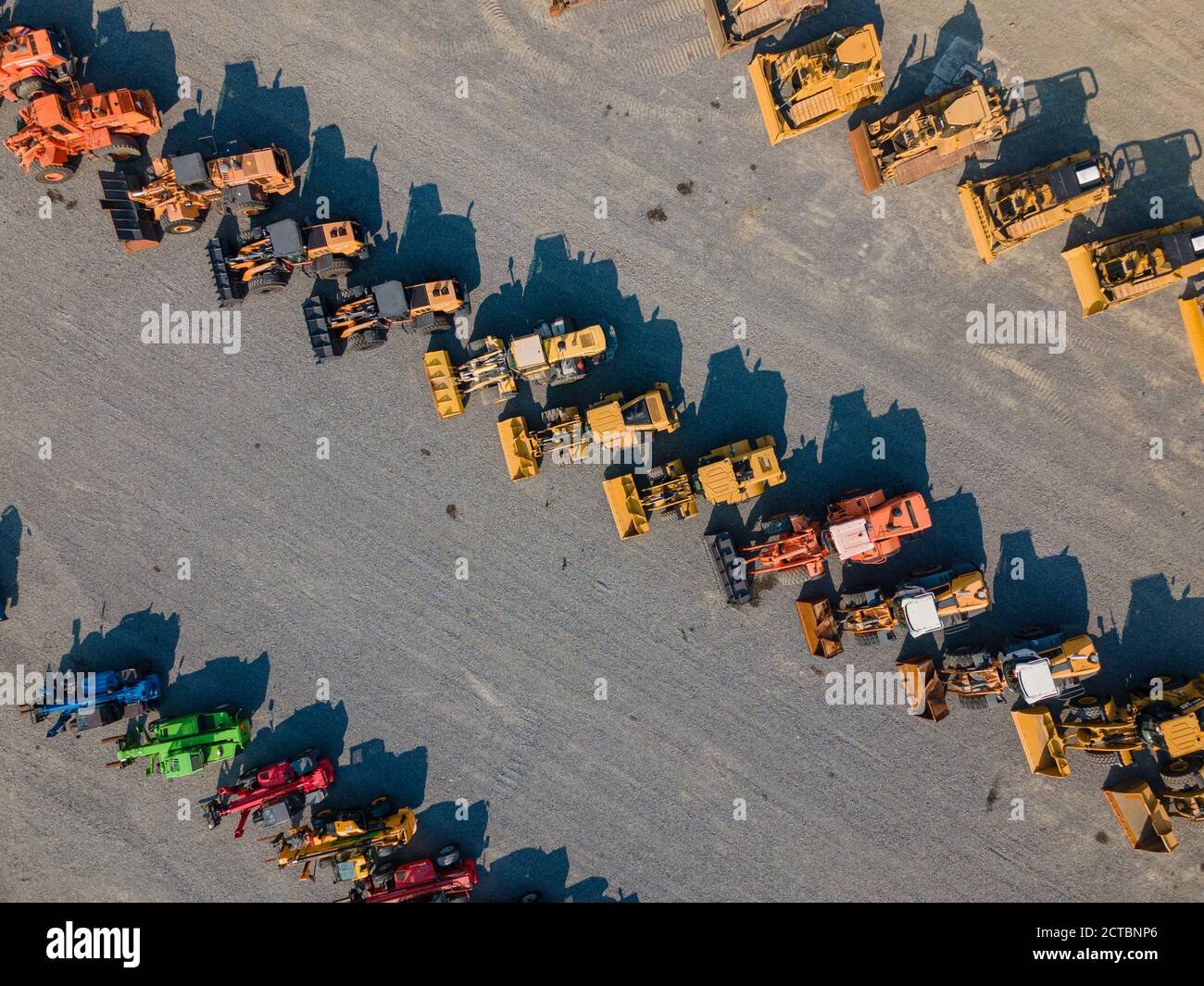 Aerial view of perfect rows of wheel loaders and other heavy machinery ...