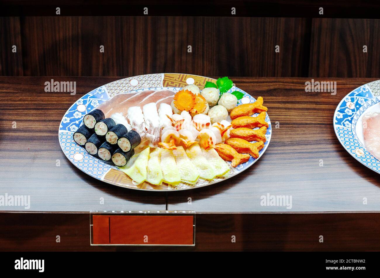 Suki shabu set on plate. fish ball, pork, shrimp on wooden shelf in ...