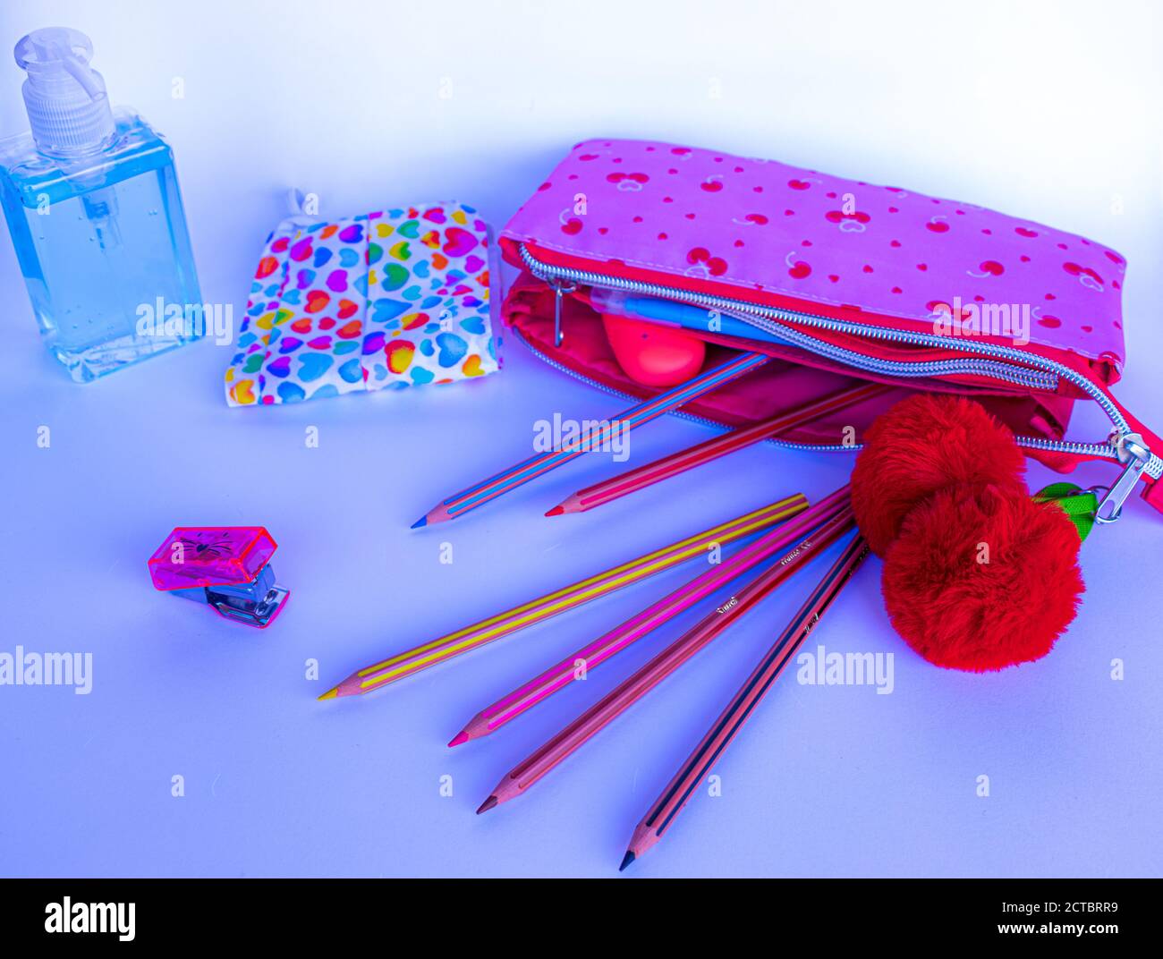 A closeup of a girly pencil case with face mask and hand sanitizer ...