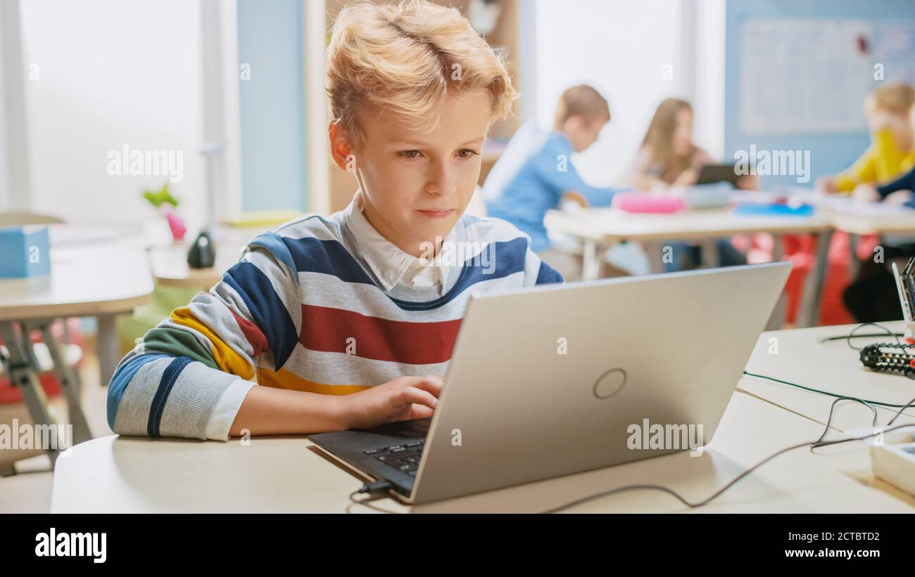 Smart Schoolboy Uses Laptop to Program Software for Robotics ...