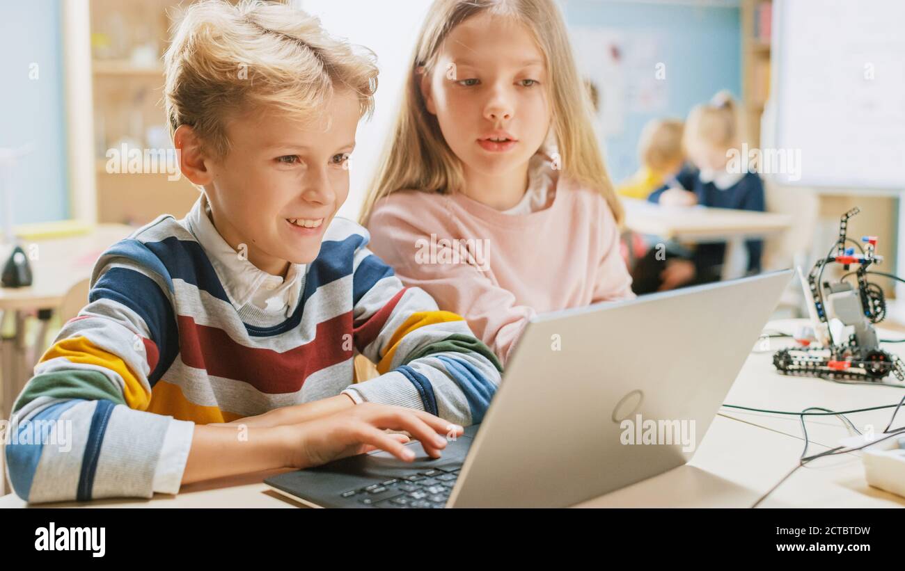 Brilliant Schoolgirl and Schoolboy Talk and Use Laptop to Program ...