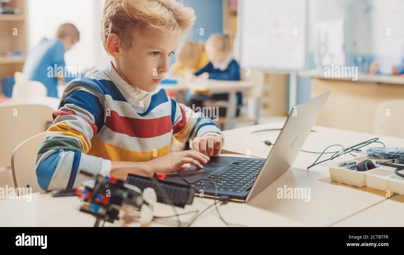 Young Schoolboy Uses Laptop to Program Software for Robotics ...
