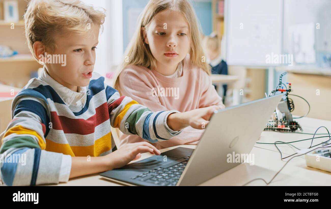 Brilliant Schoolgirl and Schoolboy Talk and Use Laptop to Program ...