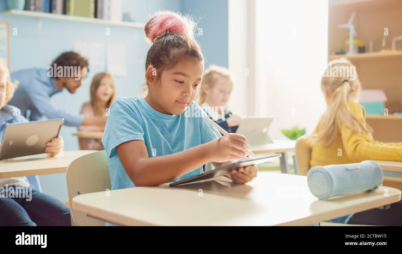 Elementary School Computer Science Class: Cute Girl Uses Digital Tablet ...