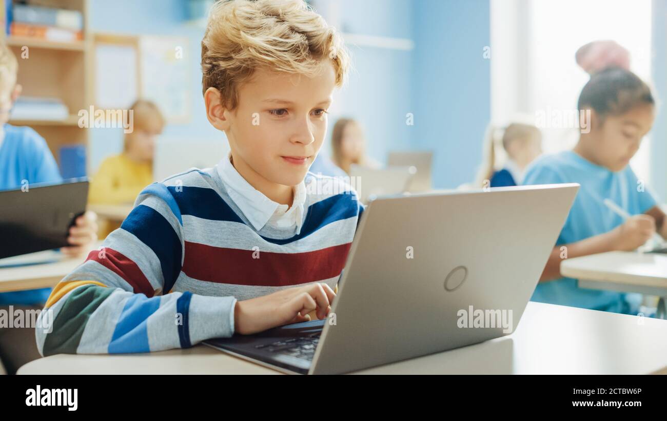 Elementary School Computer Science Class: Smart Boy Uses Laptop ...