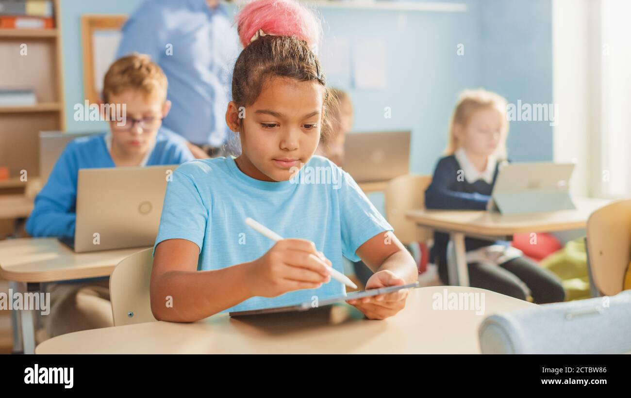 Elementary School Computer Science Class: Cute Girl Uses Digital Tablet ...