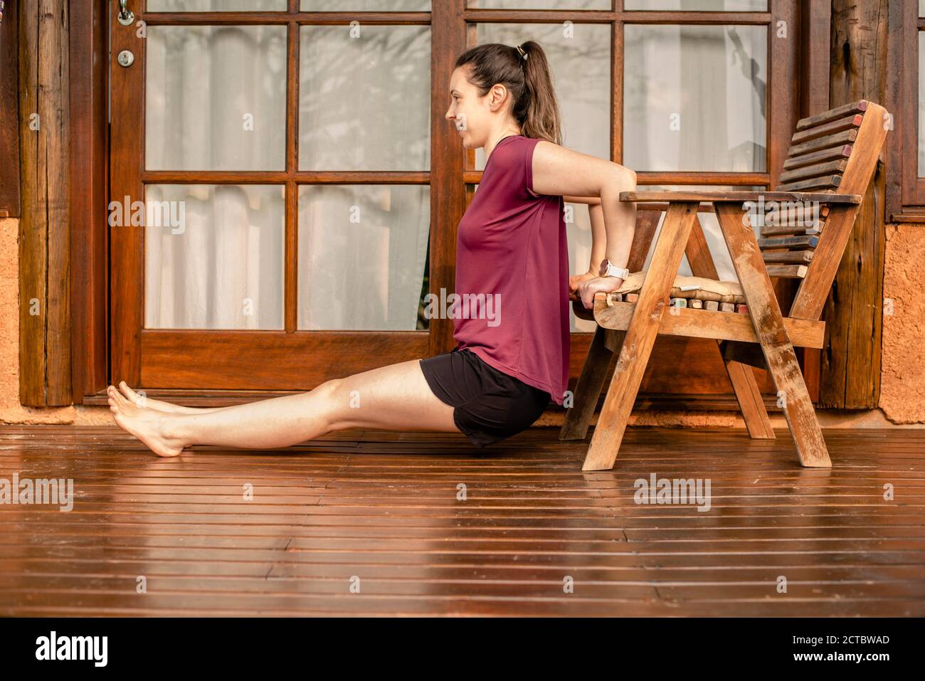 Woman doing triceps dips exercise at home Stock Photo - Alamy