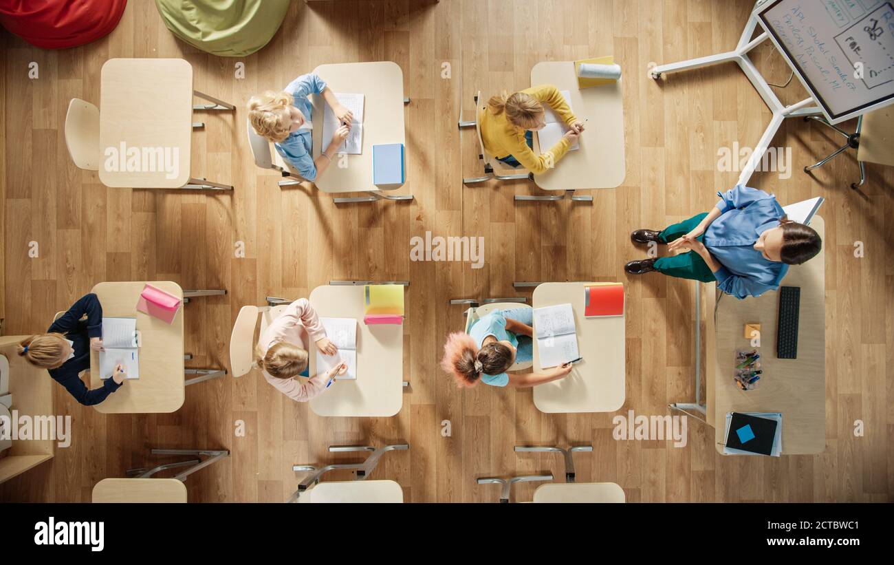 Bright Elementary School Classroom: Children Sitting at their School ...
