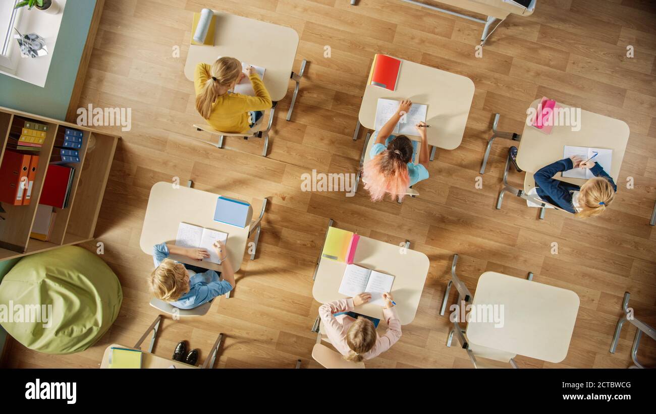 Elementary School Classroom: Children Sitting at their School Desk ...