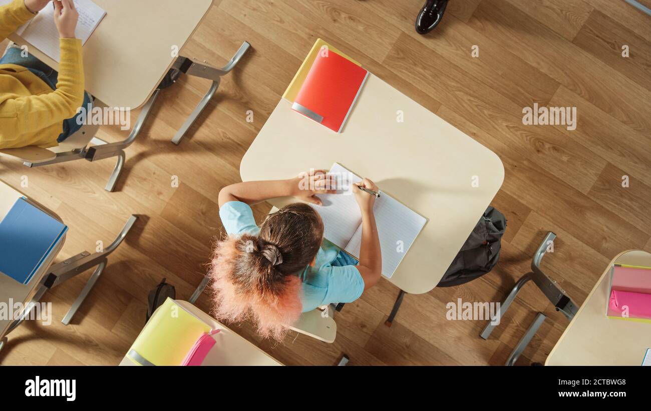 Top View Shot of Elementary School Classroom: Girl Sitting at the ...