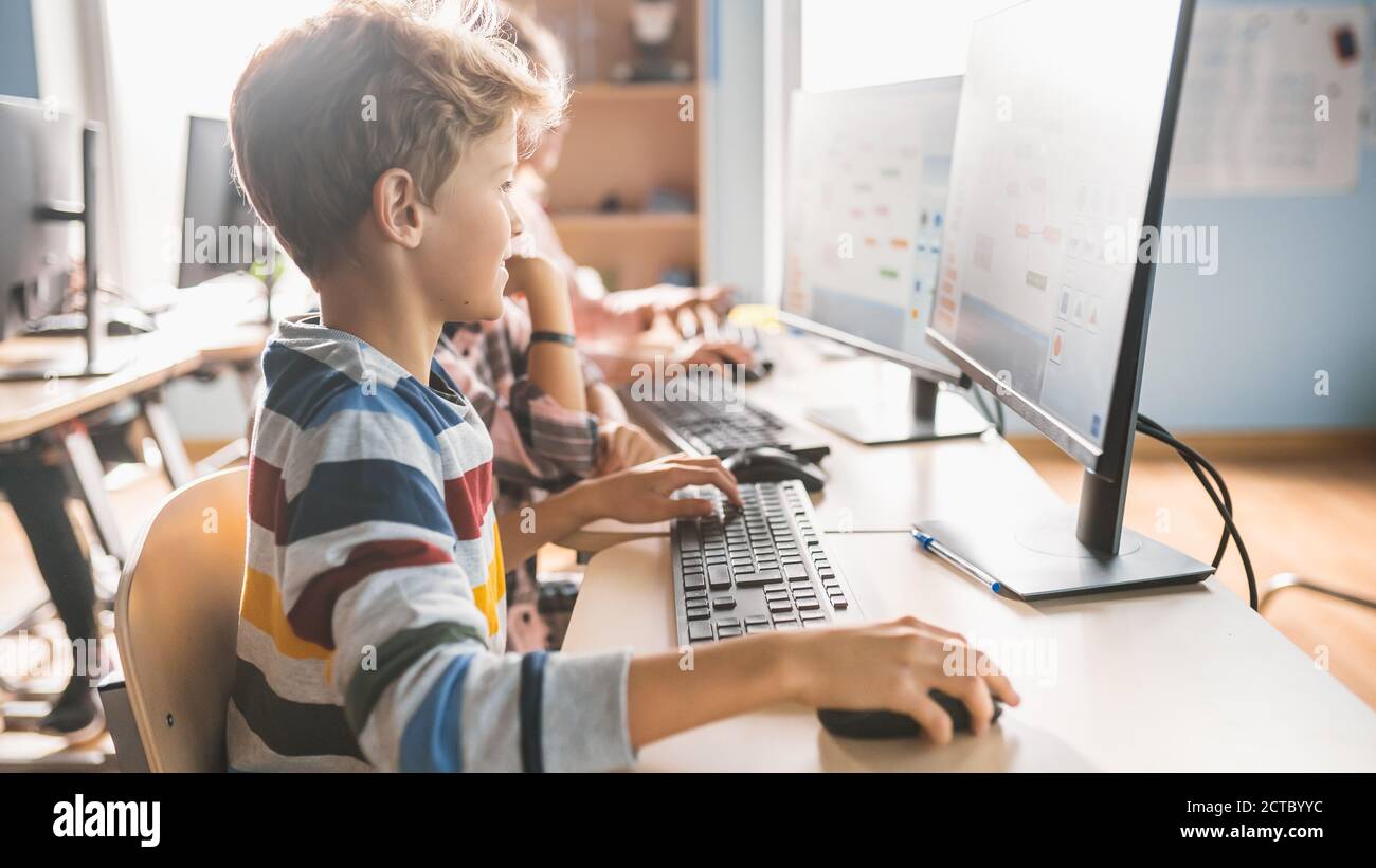 Elementary School Classroom: Smart Boy Uses Personal Computer, Learning ...