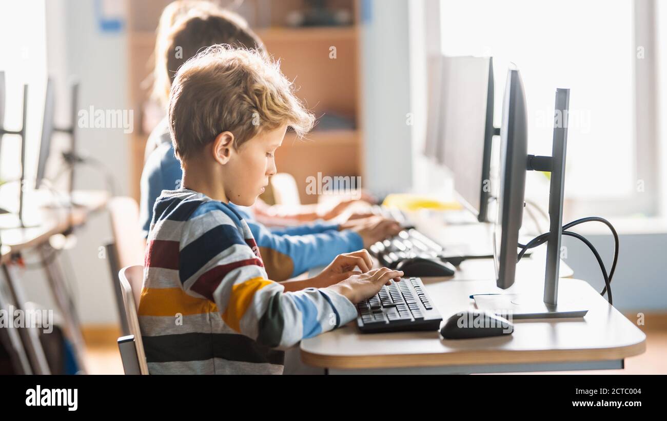 Elementary School Computer Science Classroom: Cute Little Boy Uses ...