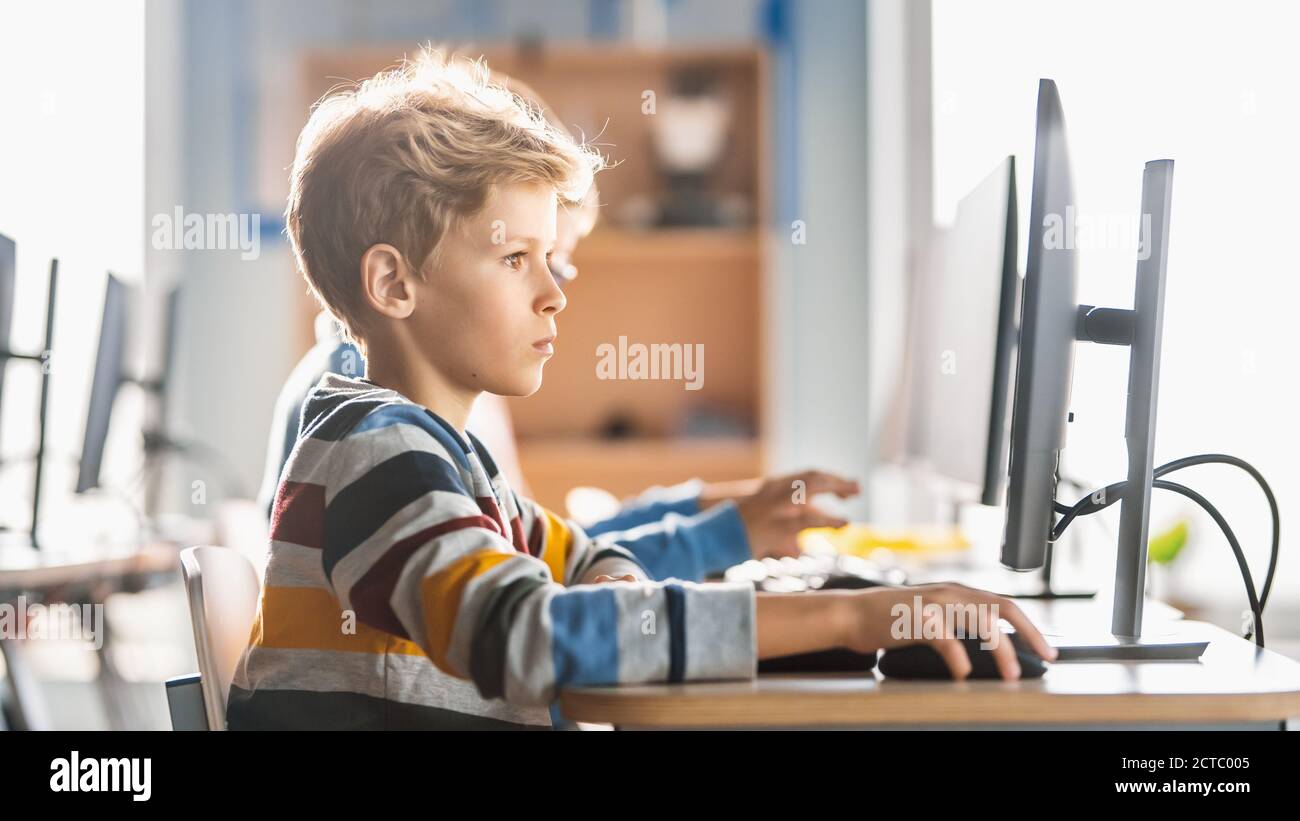 Elementary School Computer Science Classroom: Cute Little Boy Uses ...