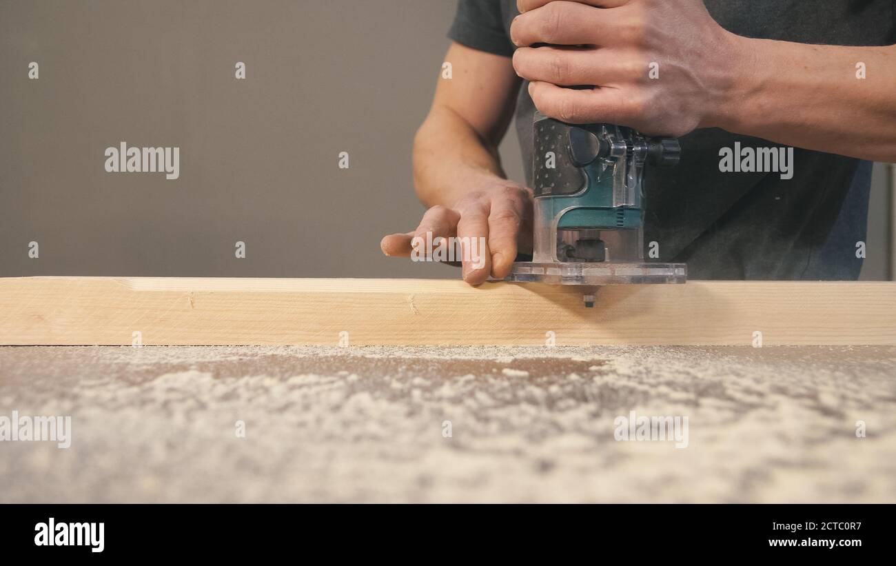 Worker bevel wooden board. Milling cutter and sawdust, closeup ...