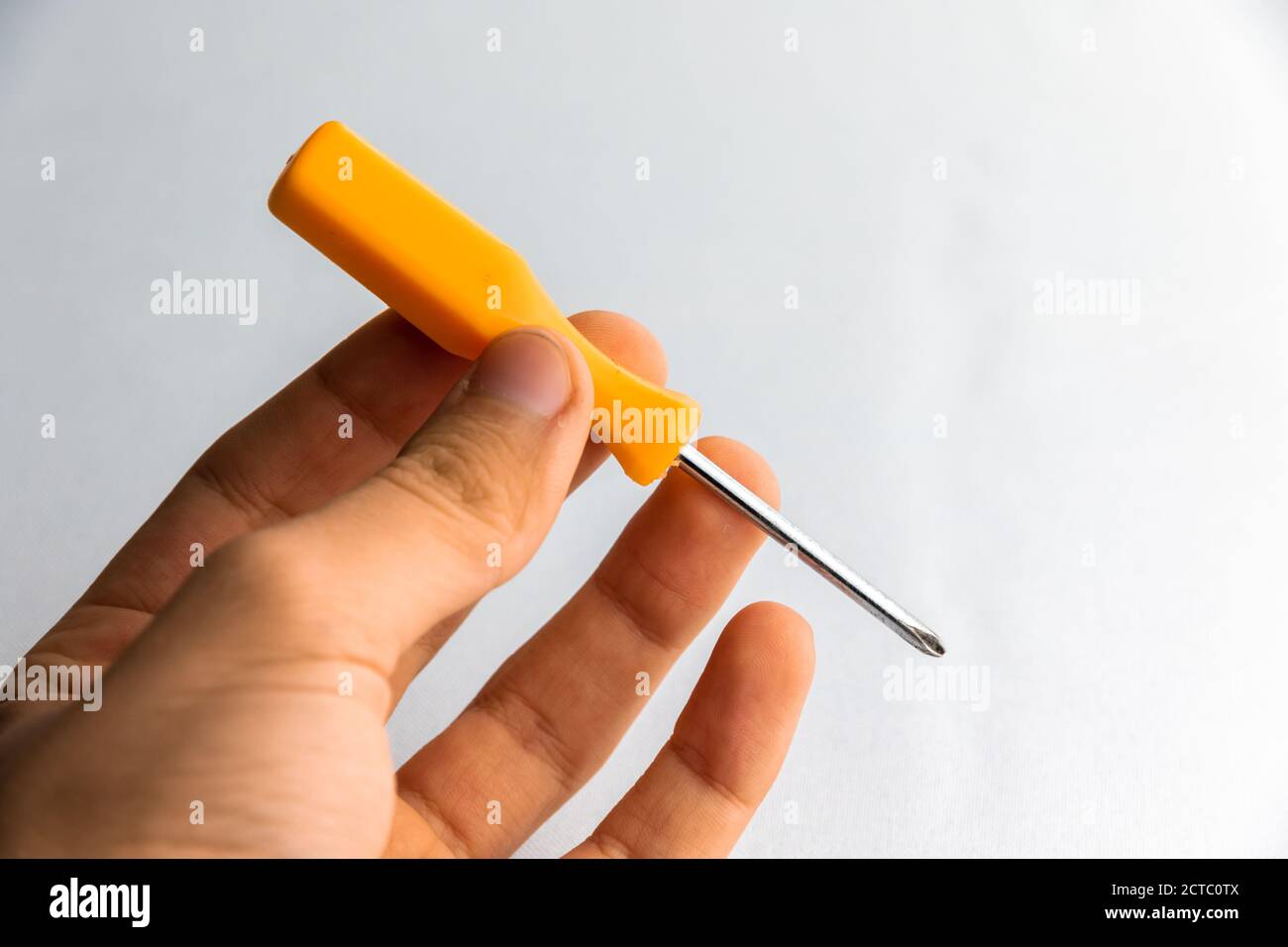 man of man that hold a screwdriver with handle rubber of red color on ...