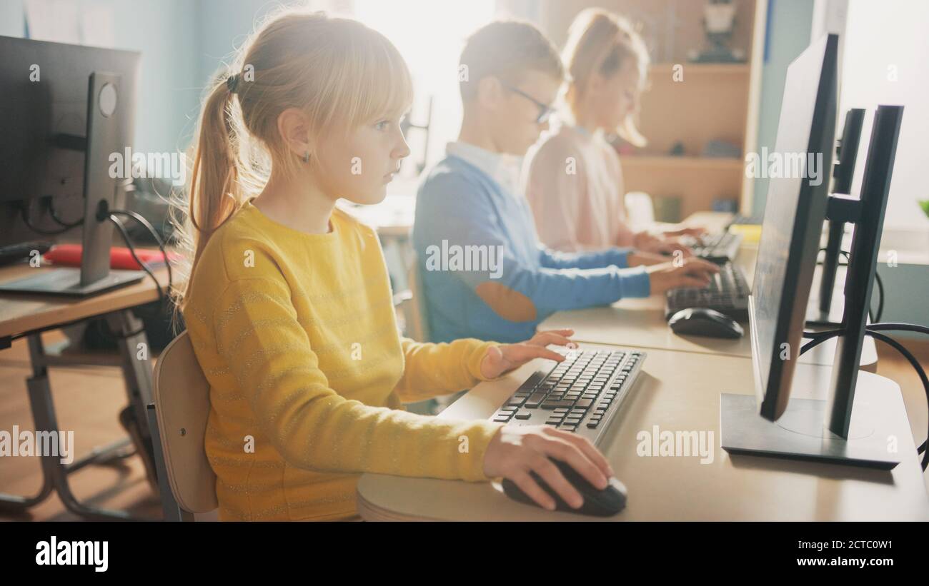Elementary School Computer Science Classroom: Cute Little Girl Uses ...