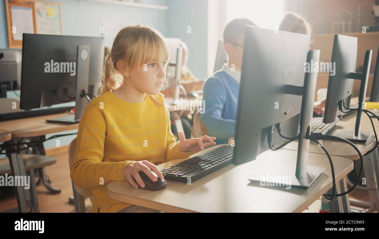 Elementary School Computer Science Classroom: Cute Little Girl Uses ...