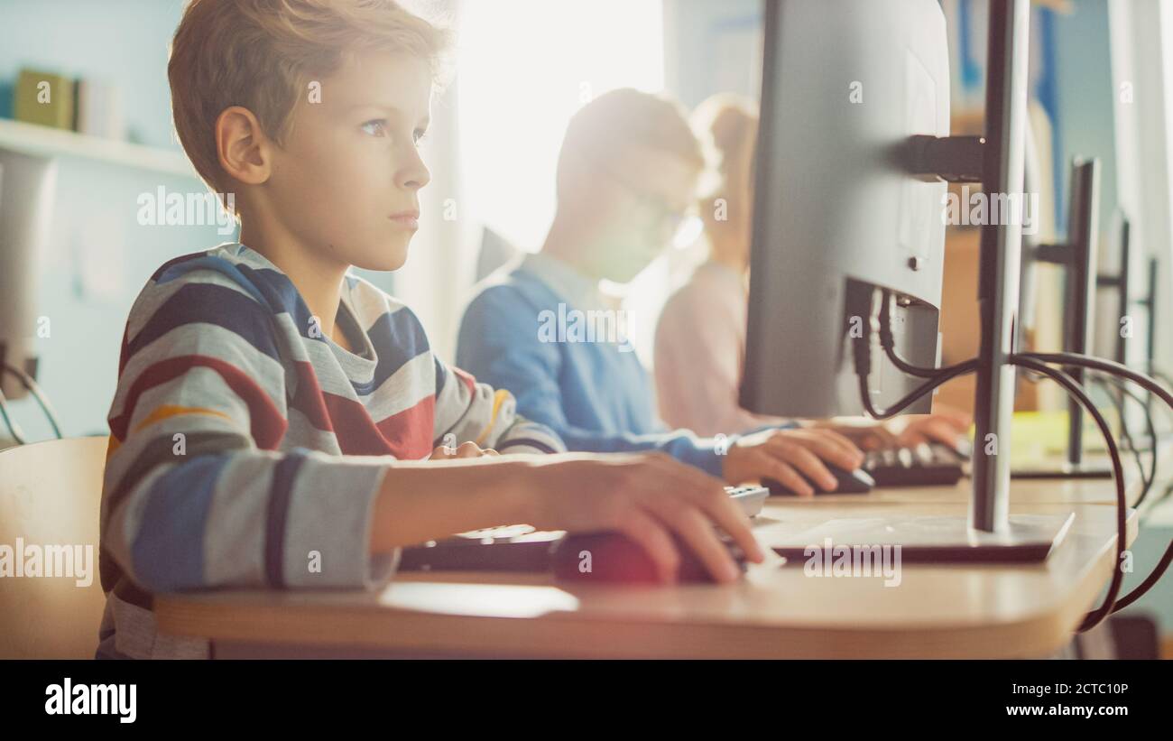 Elementary School Computer Science Classroom: Smart Little Boy Uses ...