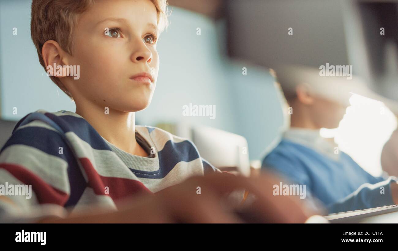 Elementary School Classroom: Smart Boy Uses Personal Computer, Learning How to Use Internet ...