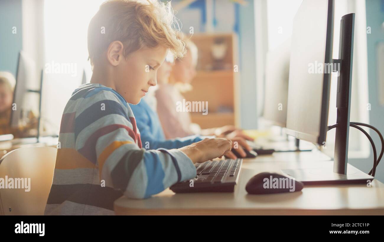 Elementary School Classroom: Smart Boy Uses Personal Computer, Learning ...