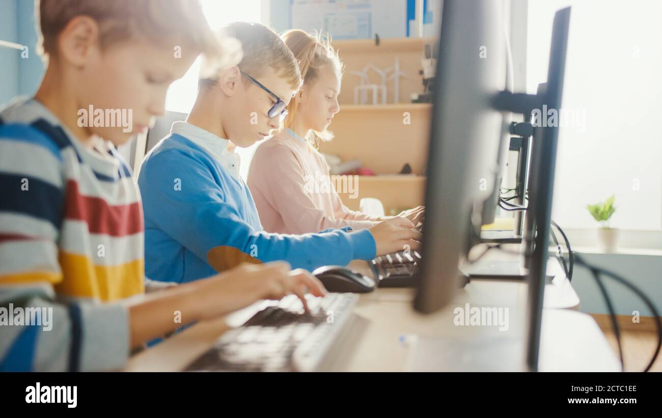 Elementary School Classroom: Portrait of a Smart Boy with Glasses Uses ...