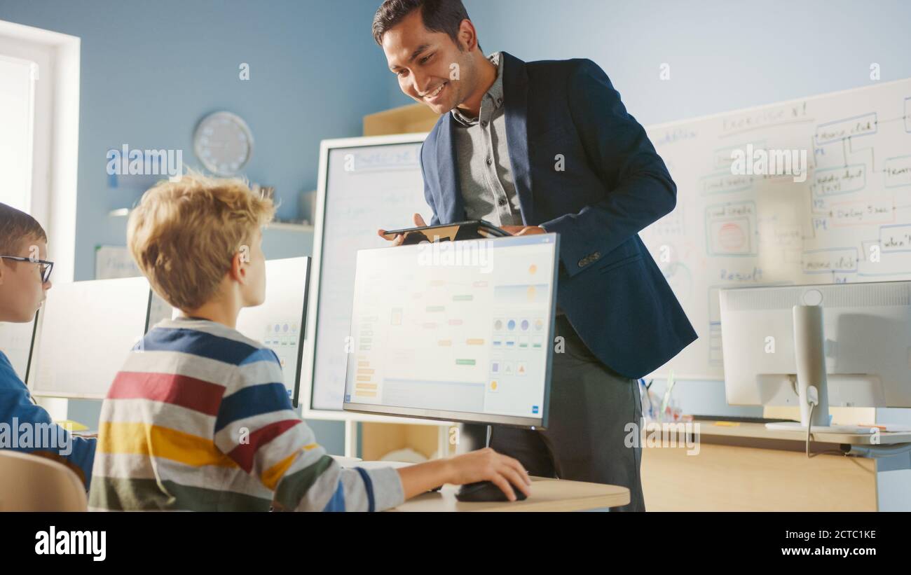 Elementary School Computer Science Classroom: Teacher Uses Tablet ...