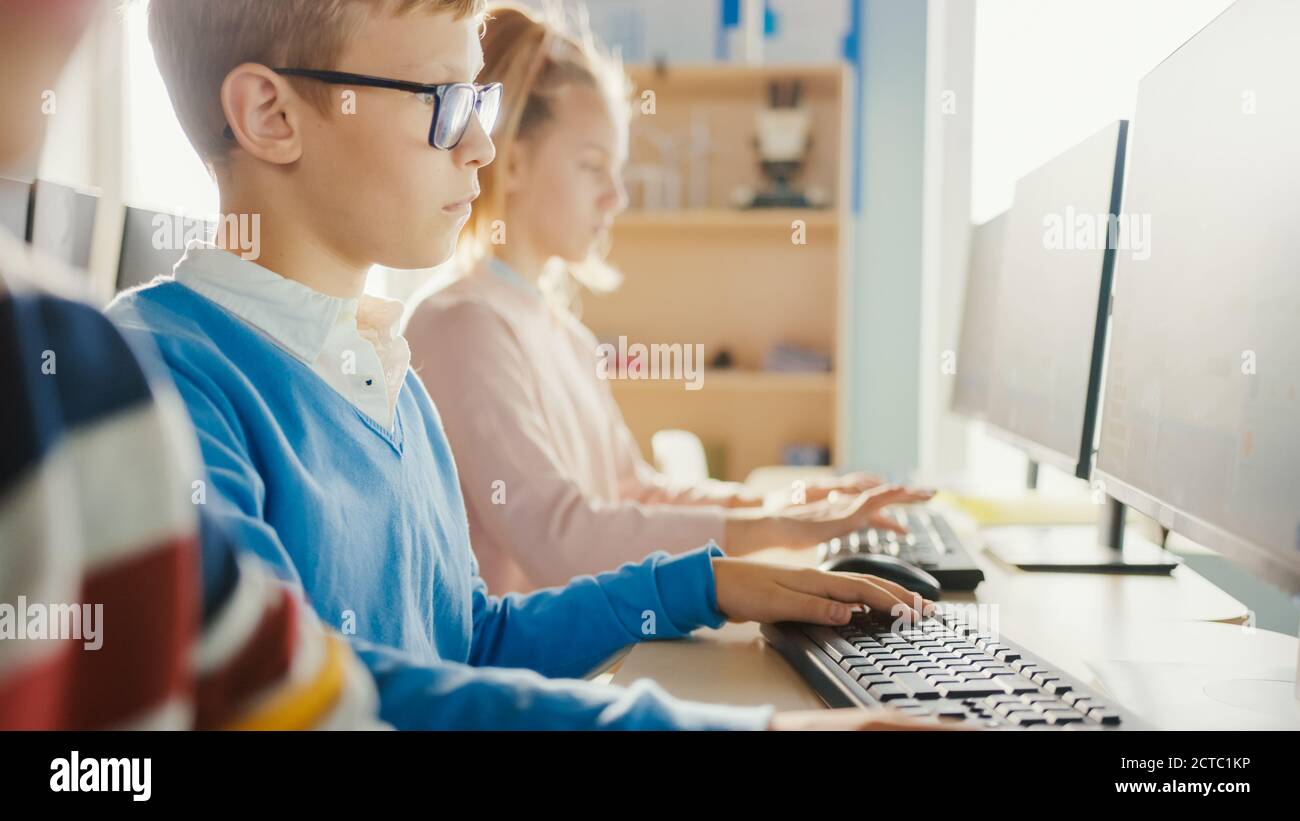 Elementary School Classroom: Portrait of a Smart Boy with Glasses Uses ...
